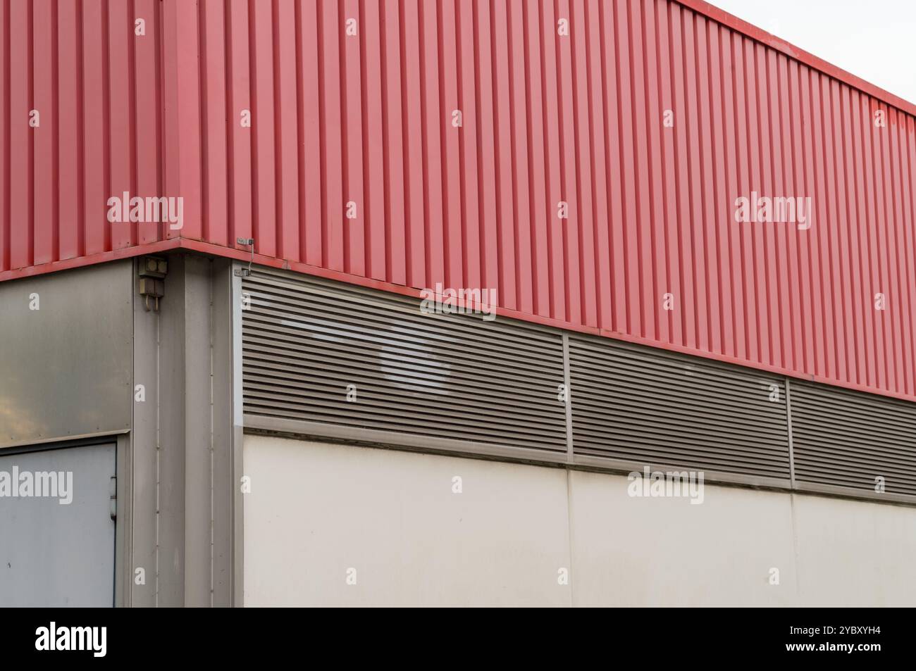 Red industrial building facade featuring ventilation grille, showcasing ...