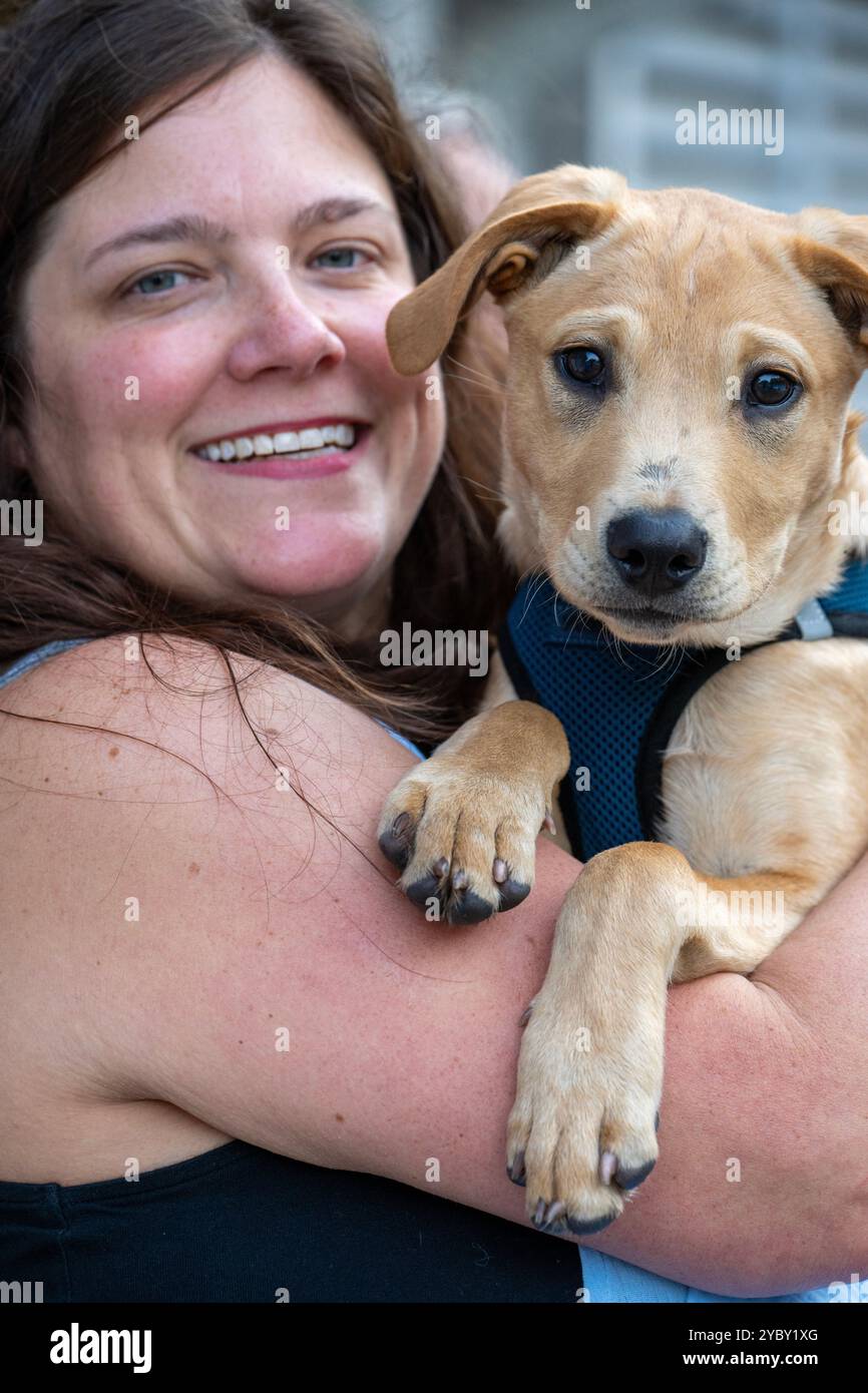 Portrait of a dog owner and her puppy. At a condominium community in ...