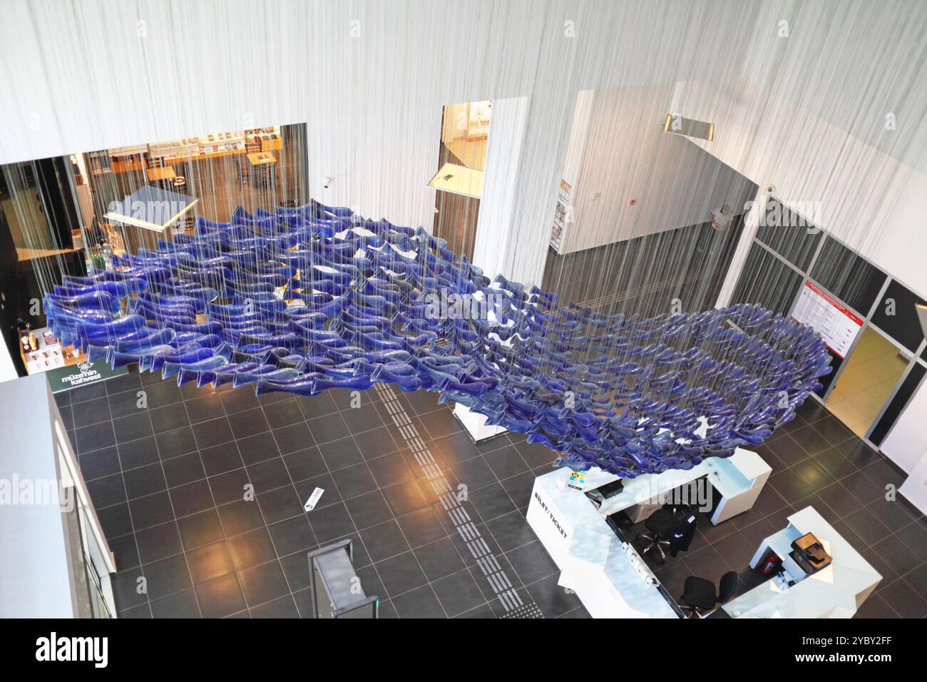 Installation of blue glass shaped like river fish, overhanging the ...