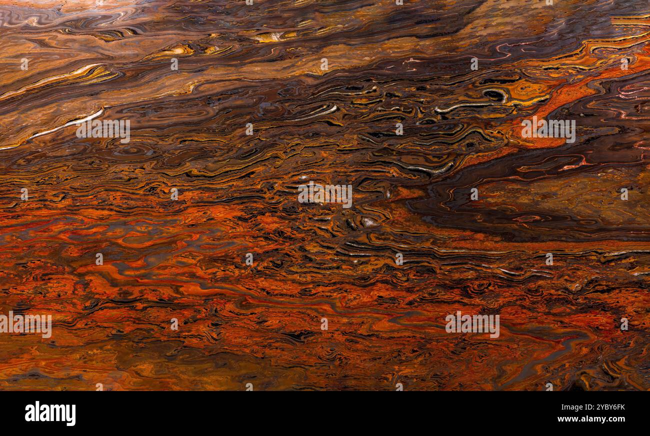 Natural granite stone texture featuring swirling patterns in warm ...