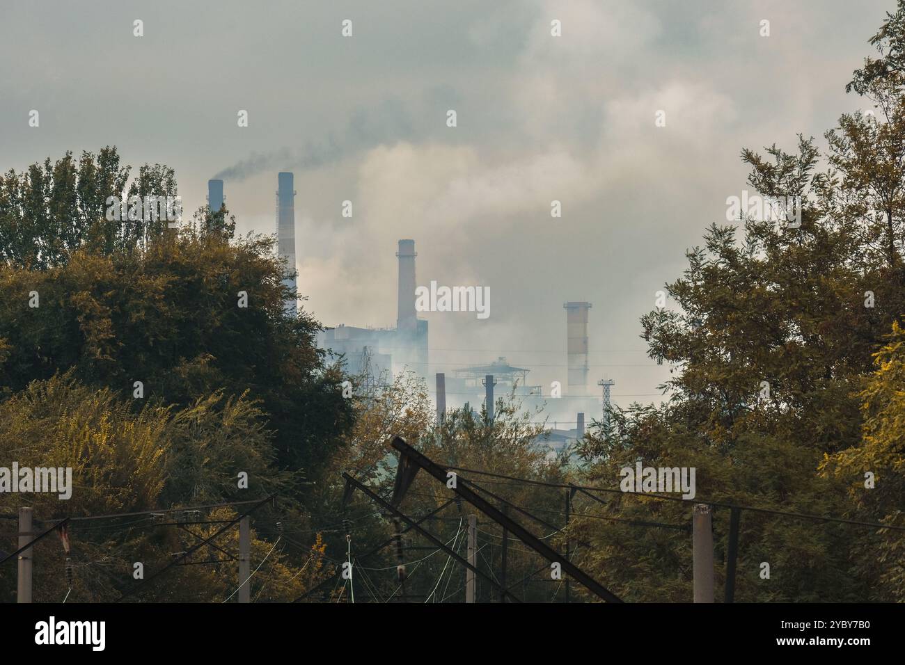 The landscape shows factories emitting smoke, contrasting with vibrant ...