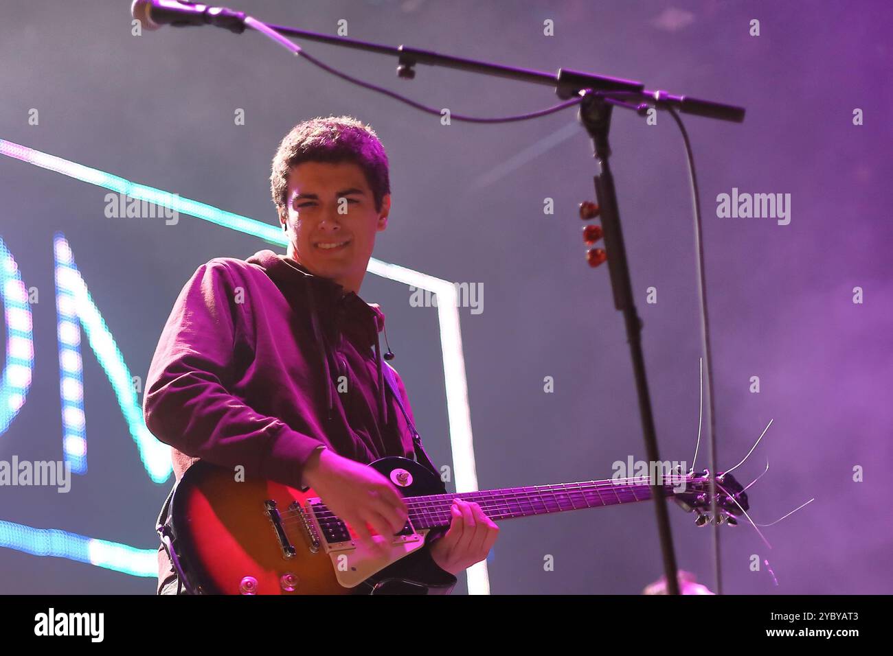 Rock guitarist playing electric guitar and singing on stage during a ...