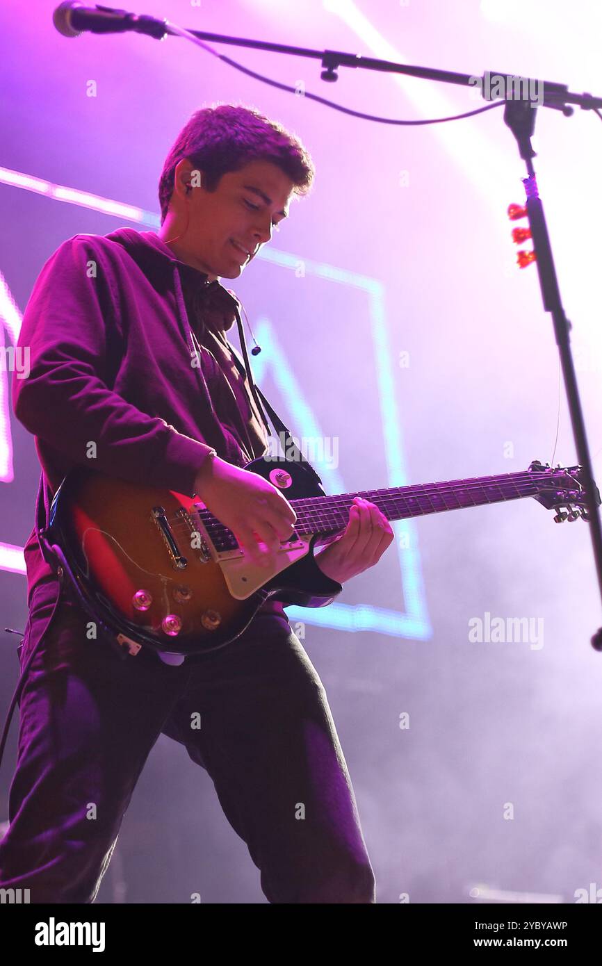 Rock guitarist playing electric guitar and singing on stage during a ...