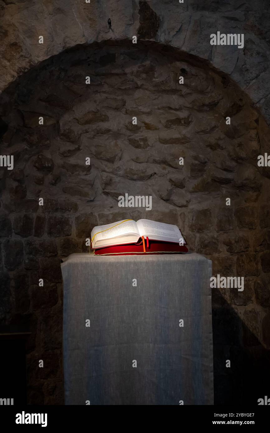 the holy bible illuminated from above resting on a pulpit in medieval ...