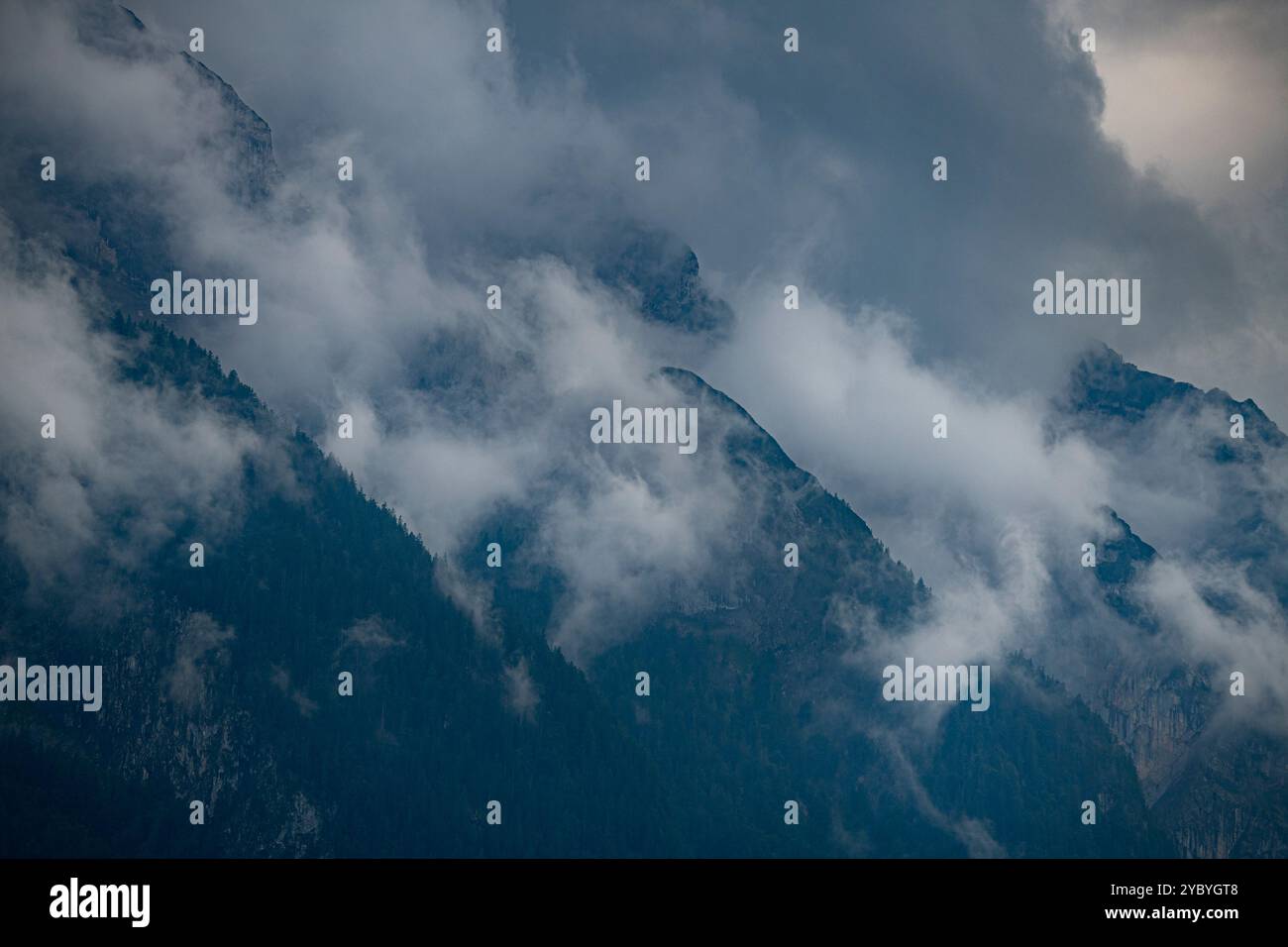 Moody Alpine Landscape: Dense Clouds Enveloping the Rugged Peaks of ...