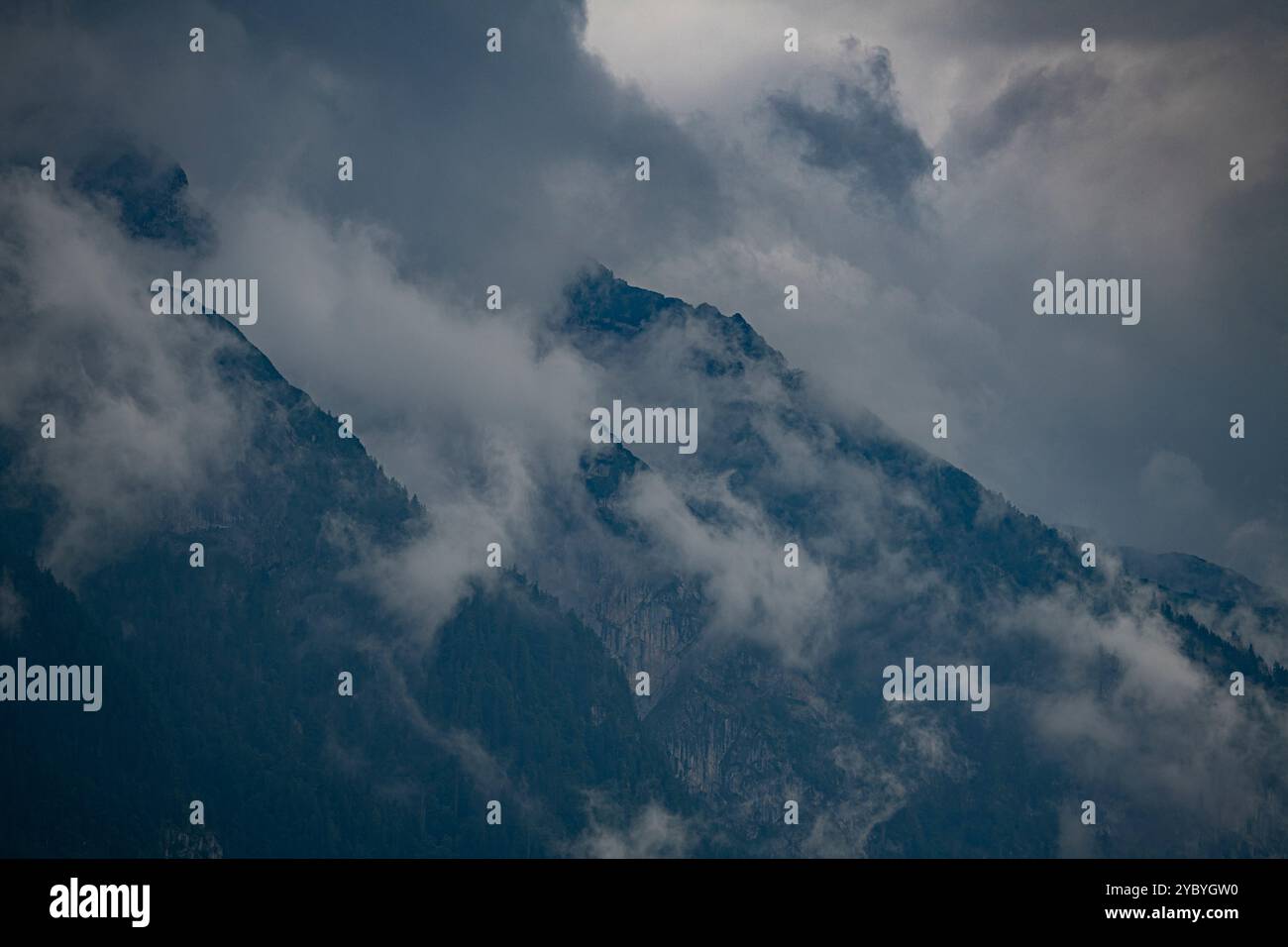 Moody Alpine Landscape: Dense Clouds Enveloping the Rugged Peaks of ...