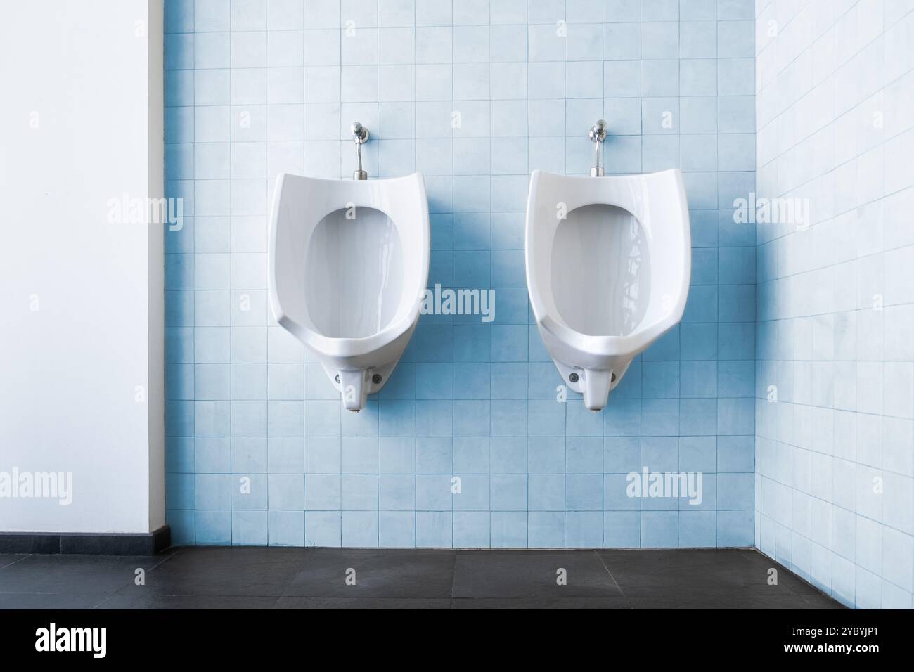 Front view of the interior of a public bathroom with two urinals for ...