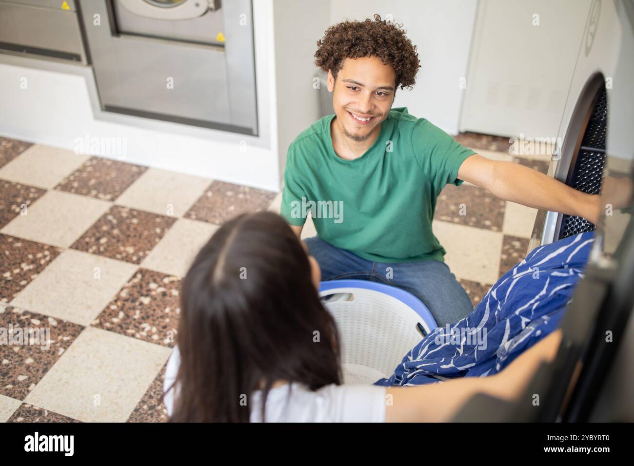 Enjoying a joyful moment while doing laundry in a modern laundromat ...