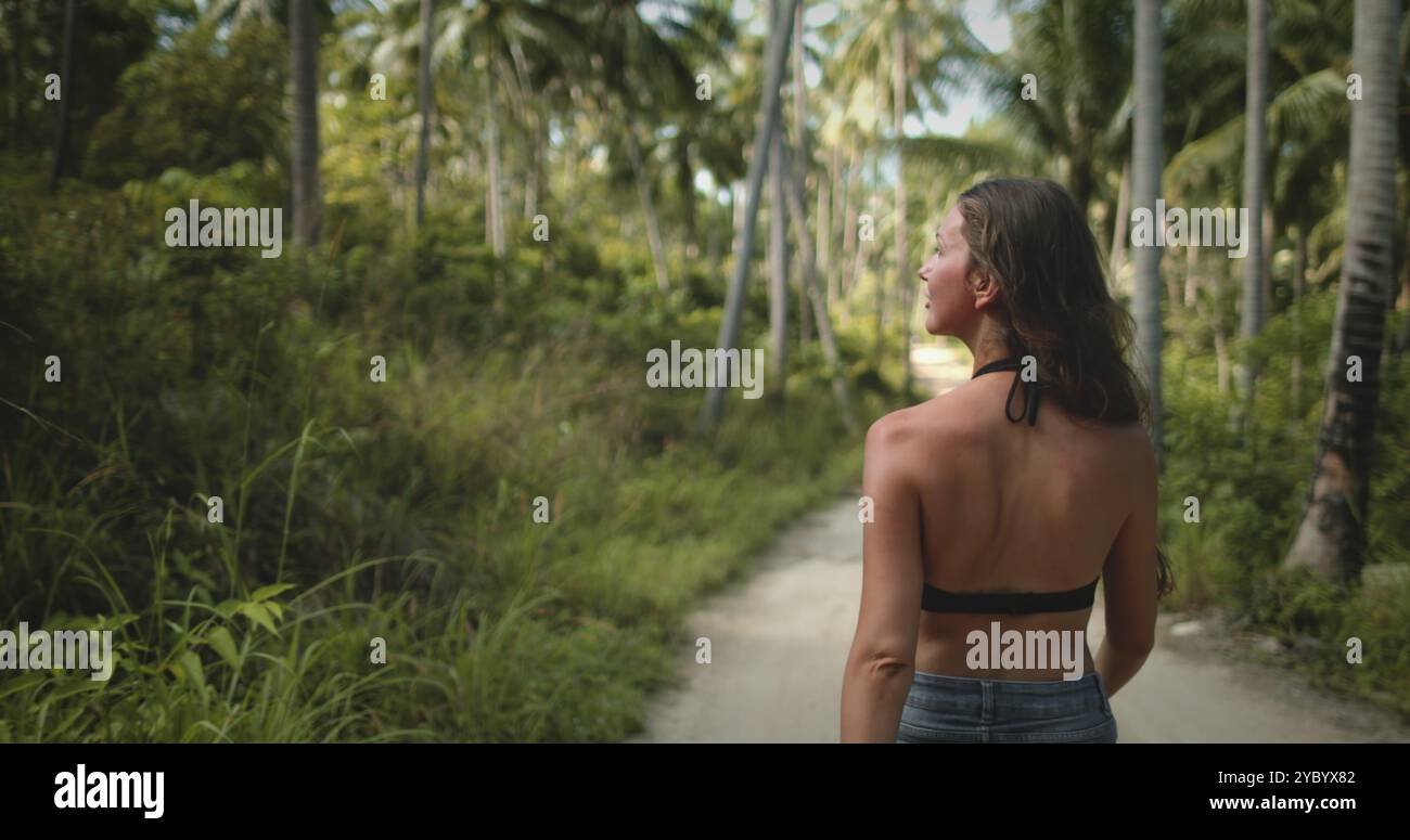 Girl walking in paradise fairy tale forest. Tropical green leaf palm ...
