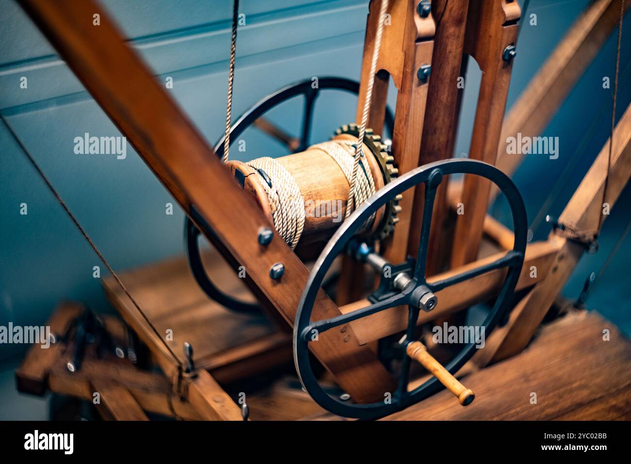Ancient wooden lifting by rope crane with lever on the blue background ...