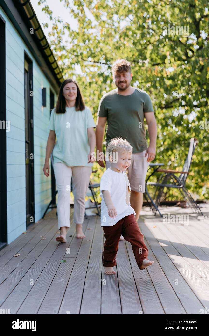 A joyful family walking together on a sunny day, with their child ...