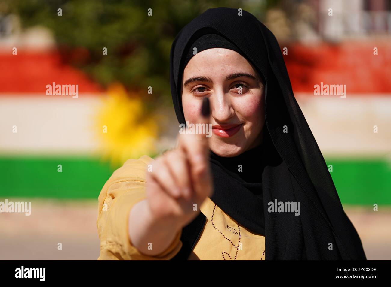 Duhok, Iraq. 20th Oct, 2024. A Kurdish girl voter shows her ink-stained ...