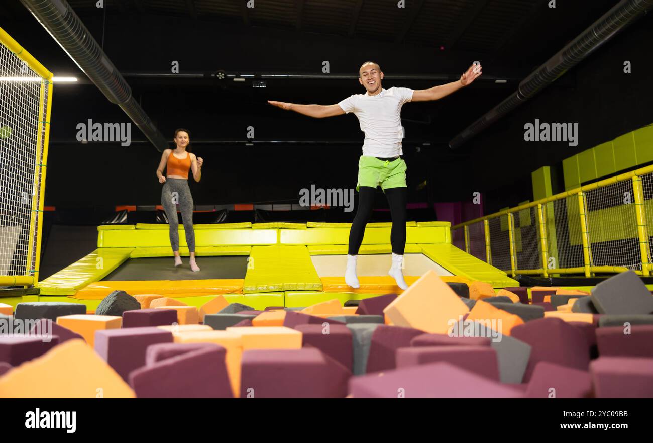 Cheerful young man jumping into foam pit at trampoline park Stock Photo ...