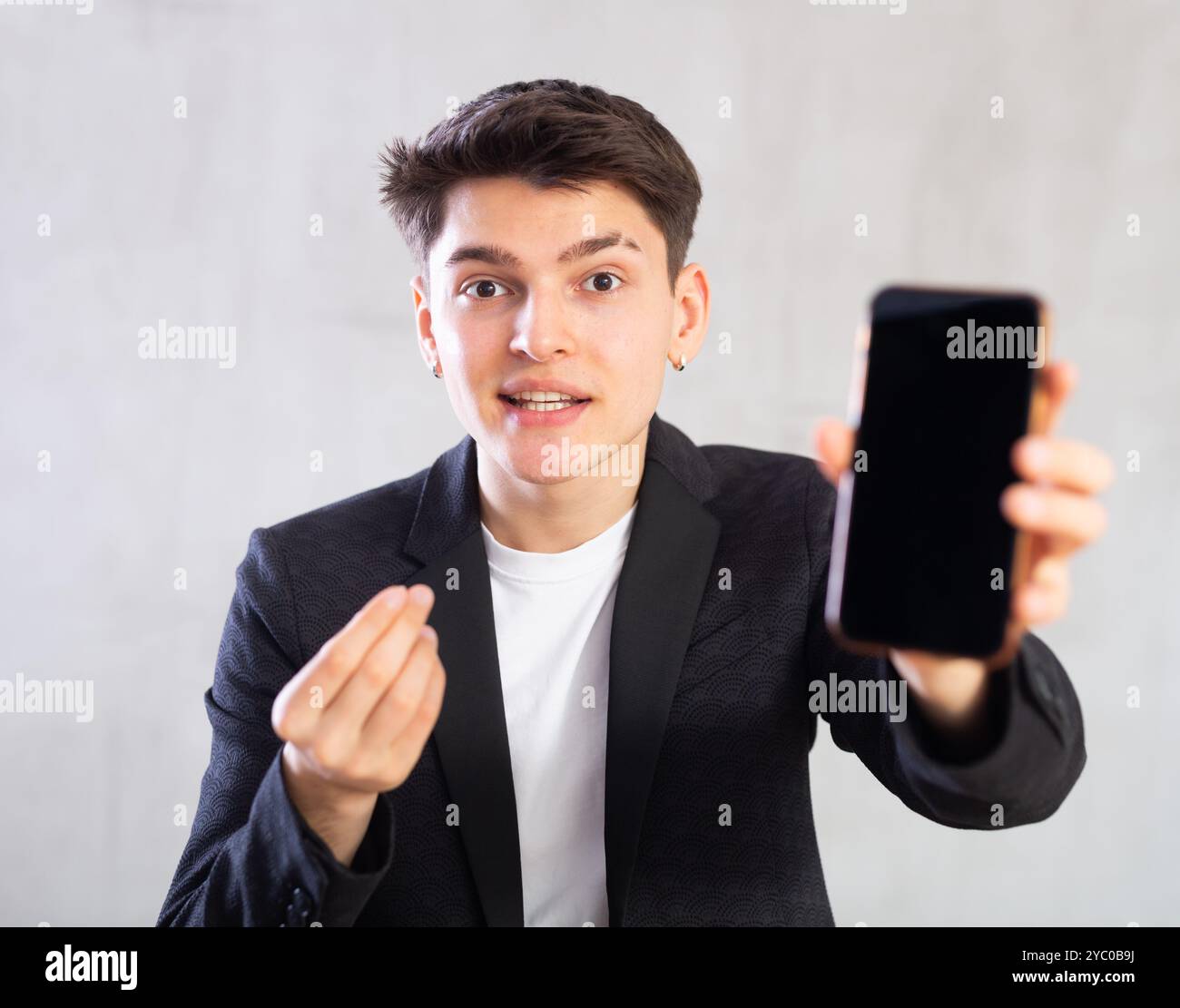 Agent in black suit jacket shows dark empty mobile phone screen and ...