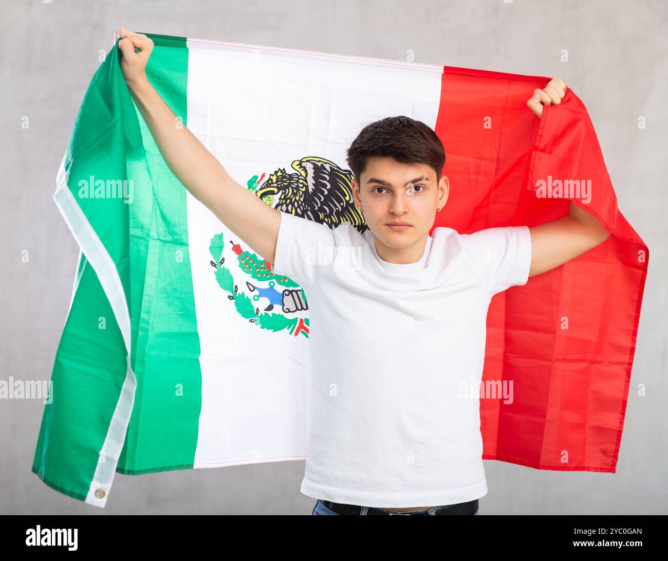Focused young guy holding Mexico flag Stock Photo - Alamy