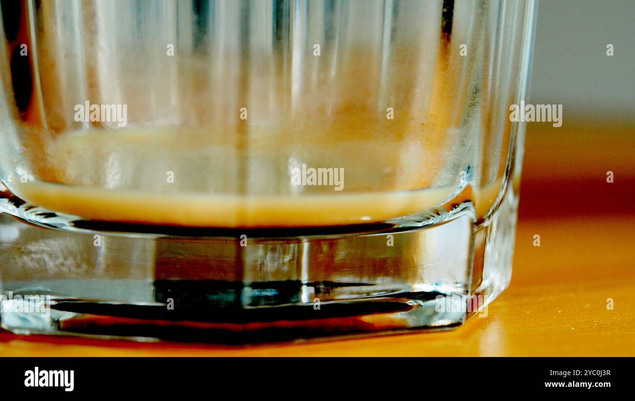 The milky dregs of a coffee served in a glass match the golden brown ...