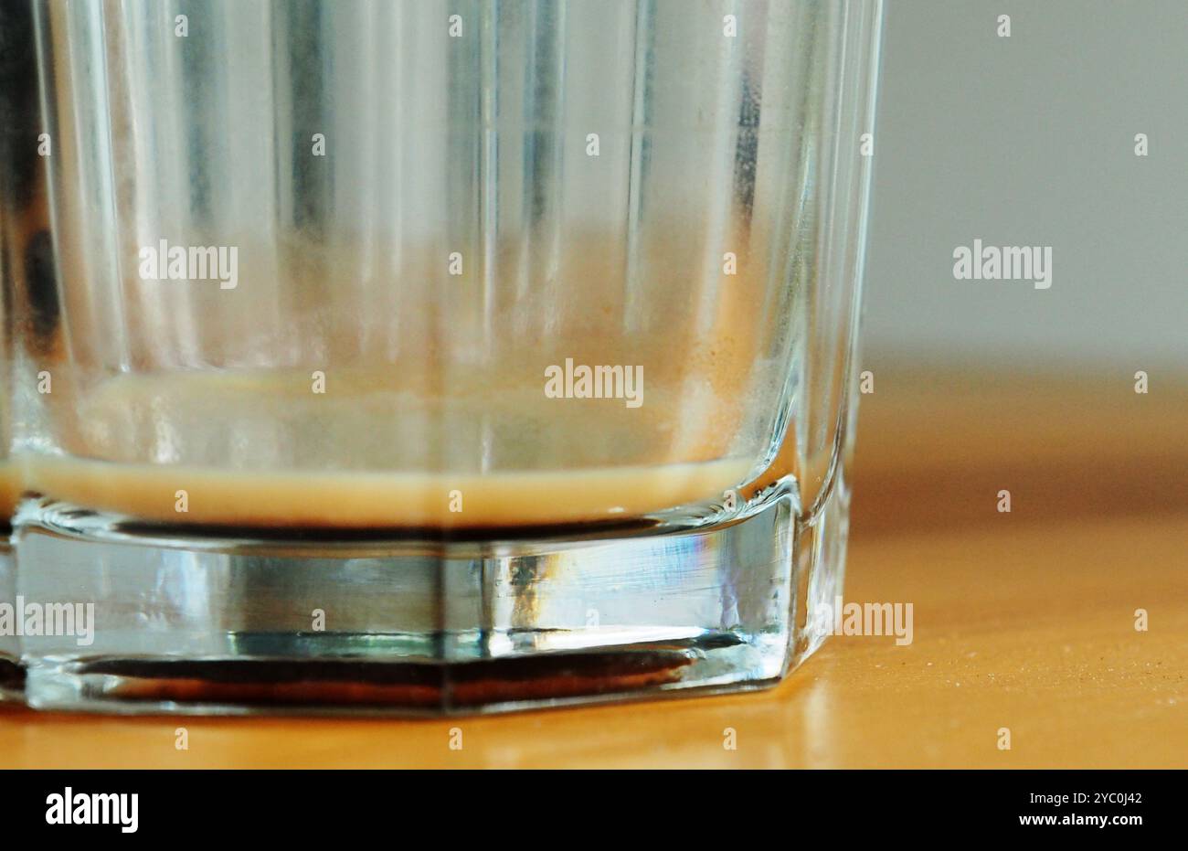 The milky dregs of a coffee served in a glass match the golden brown ...