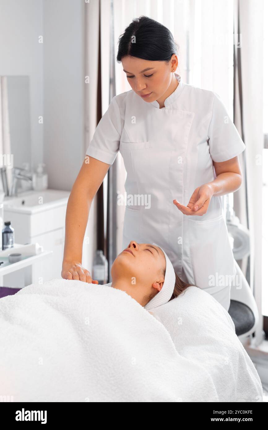 Cosmetologist woman massaging client's shoulder at beauty salon ...