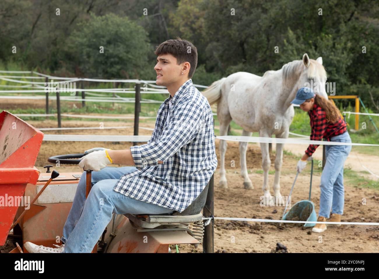 Guy sits on minitractor and drives rural vehicle, performs loading work ...