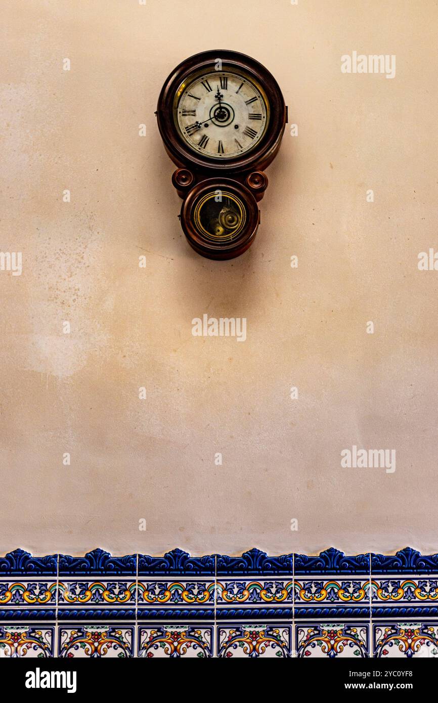 vintage clock with roman numerals hanging on yellow wall decorated with ...