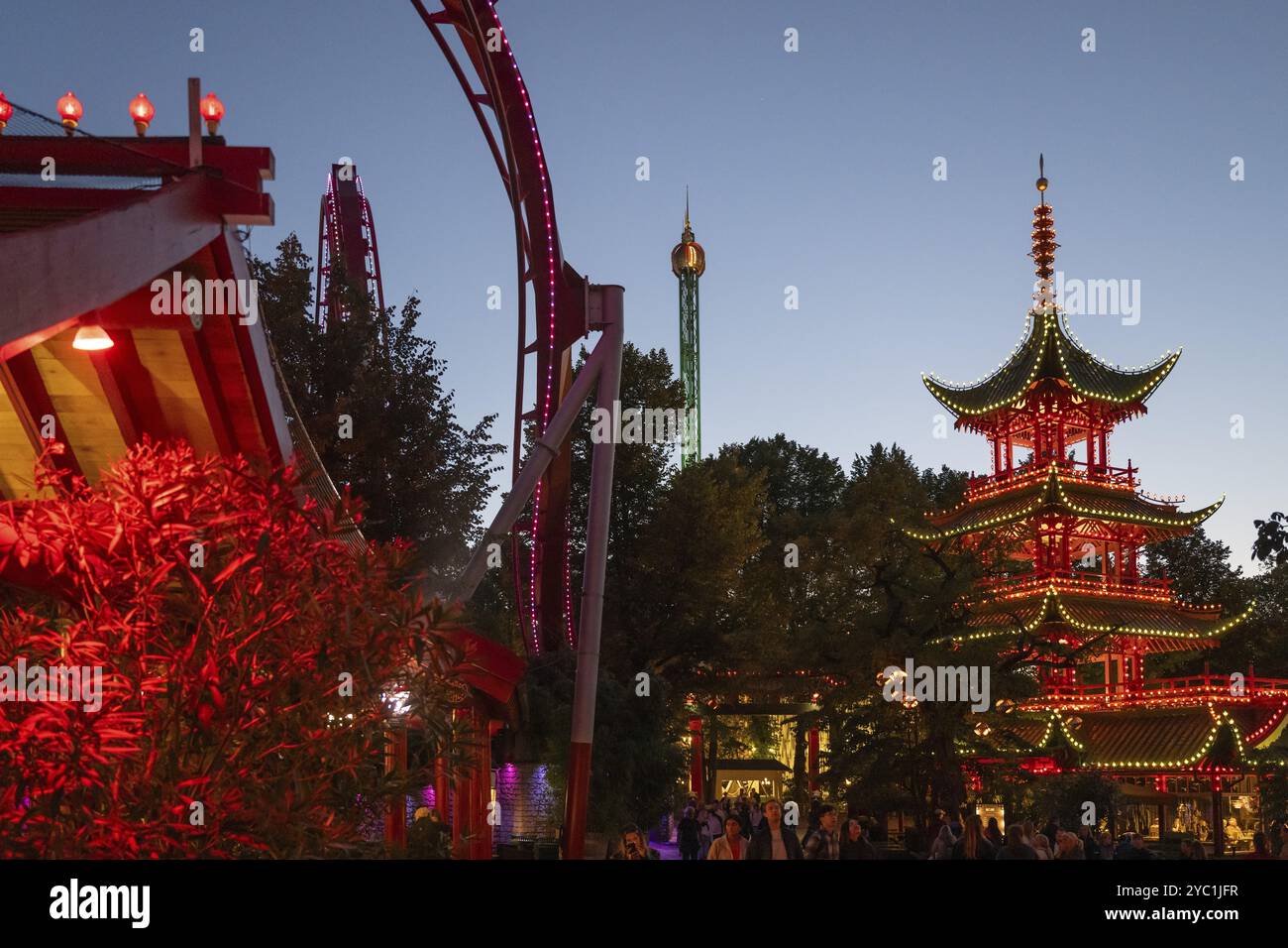 Red and yellow illuminated pagoda, roller coaster, Tivoli Amusement and ...