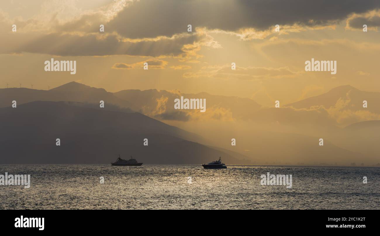 Dramatic sunset over the sea with boat silhouettes and cloudy sky, Agia ...