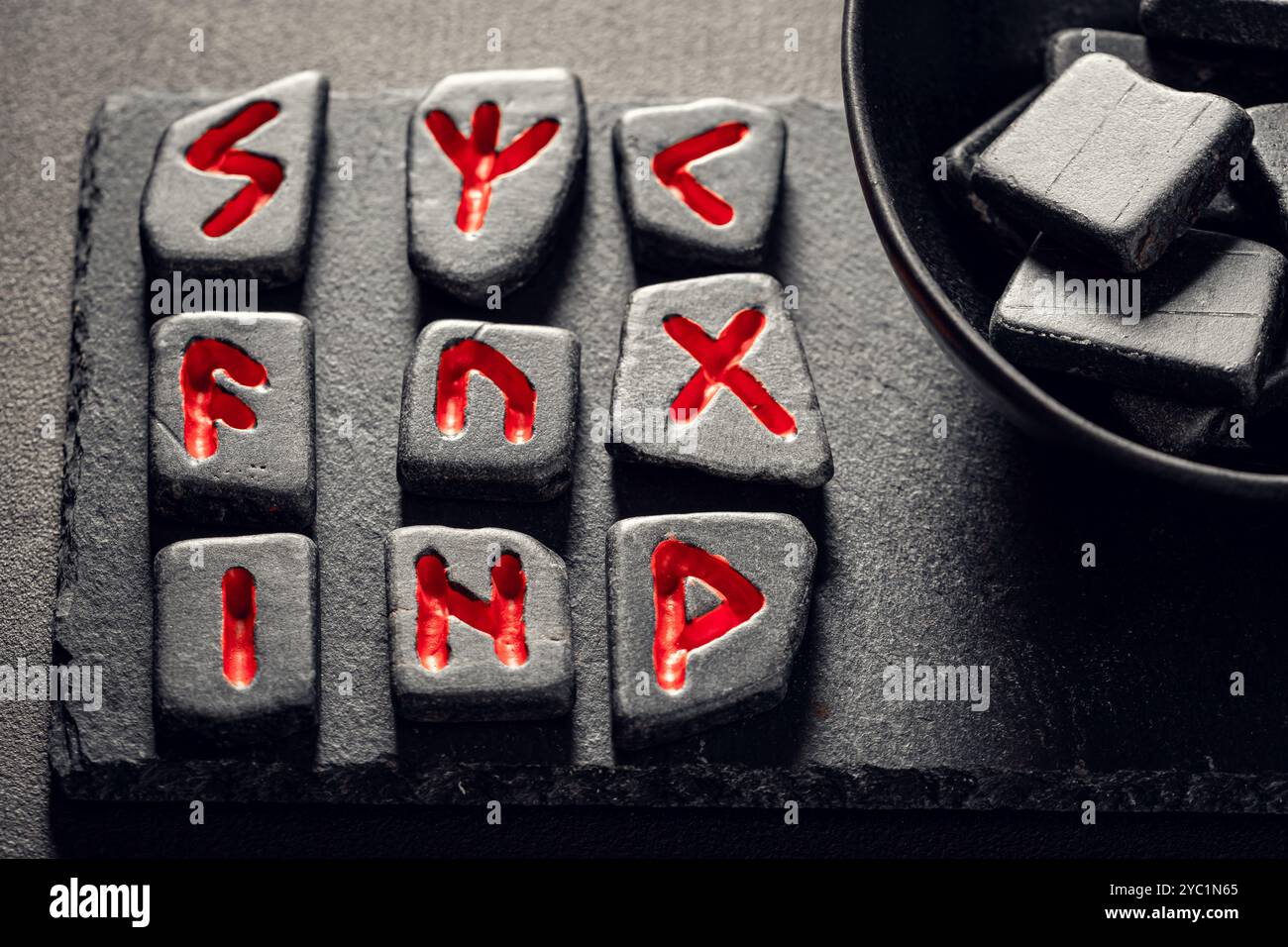 Closeup of old enchanted rune with red signs based on futhark alphabet ...