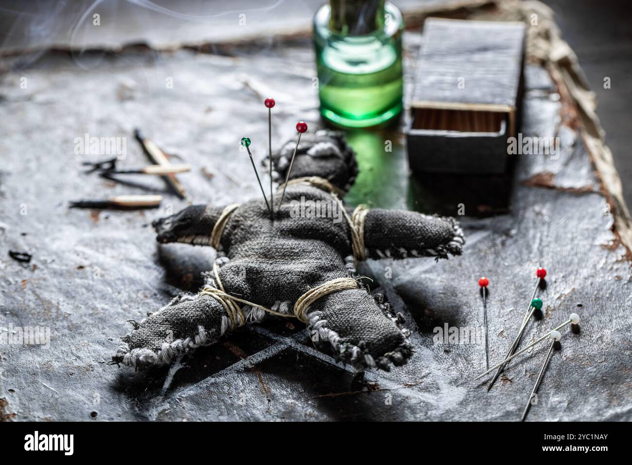 Voodoo doll, stabbed with a needle, burns and poisoned on old book ...