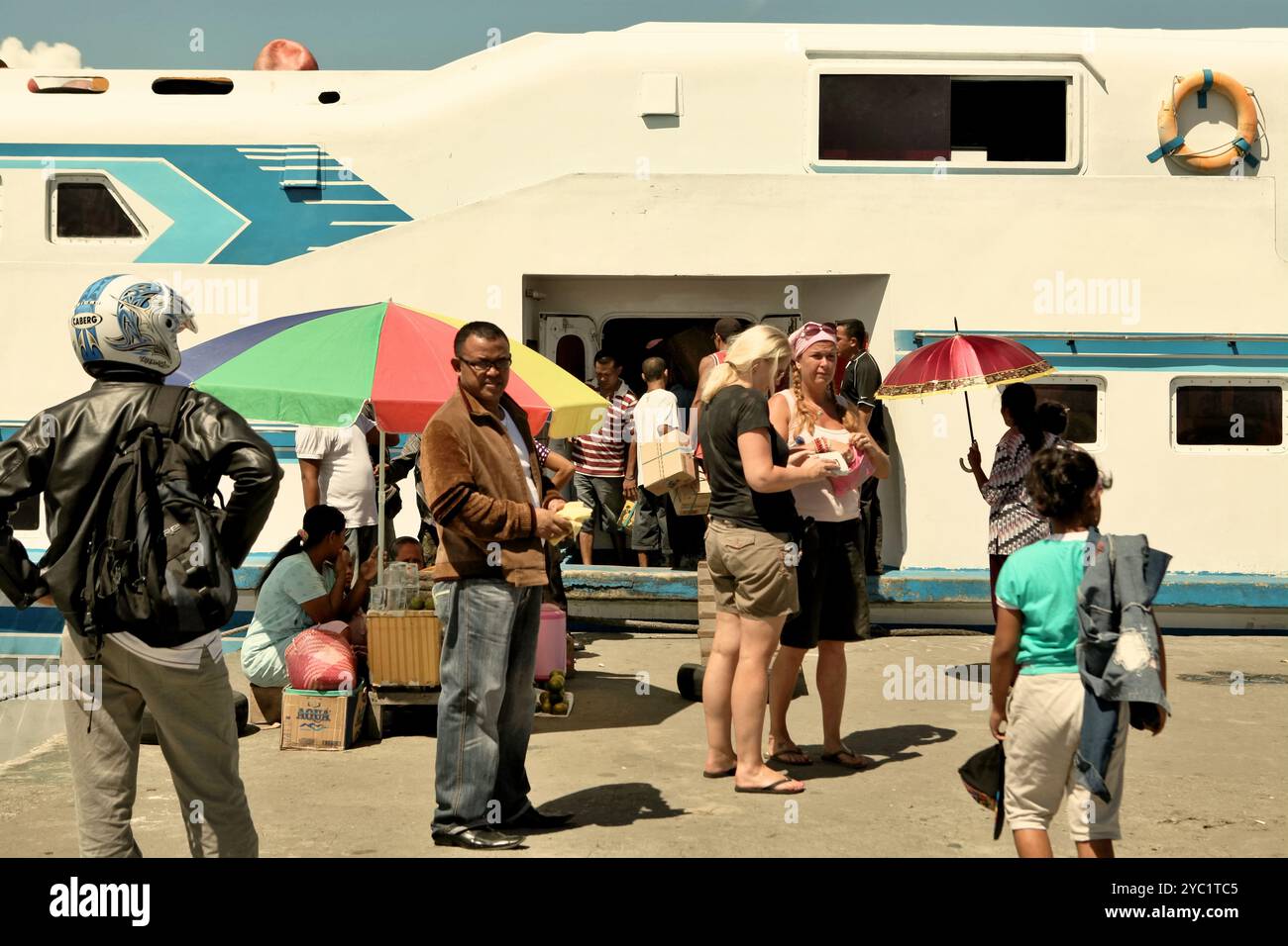 Passengers and food vendor are photographed on harbor platform, in a ...