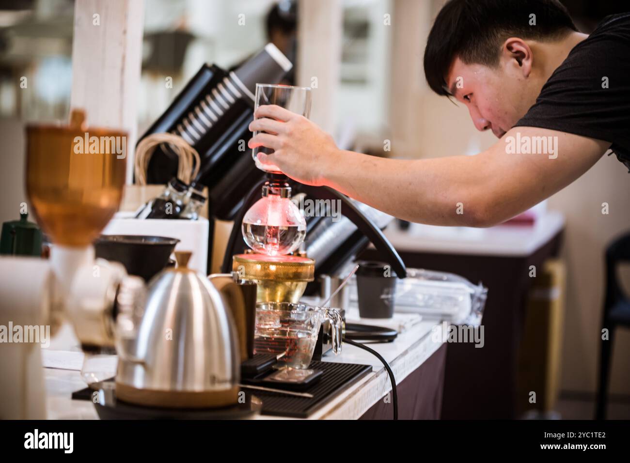 Professional coffee maker - Barista using coffee siphon brewing hot ...