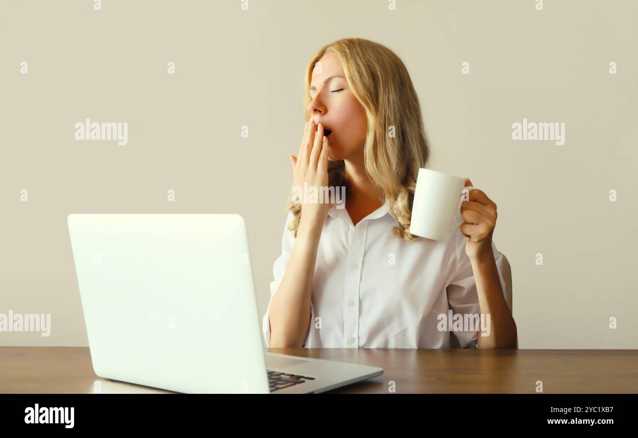 Tired overworked sleeping woman employee yawns, drinks coffee while ...