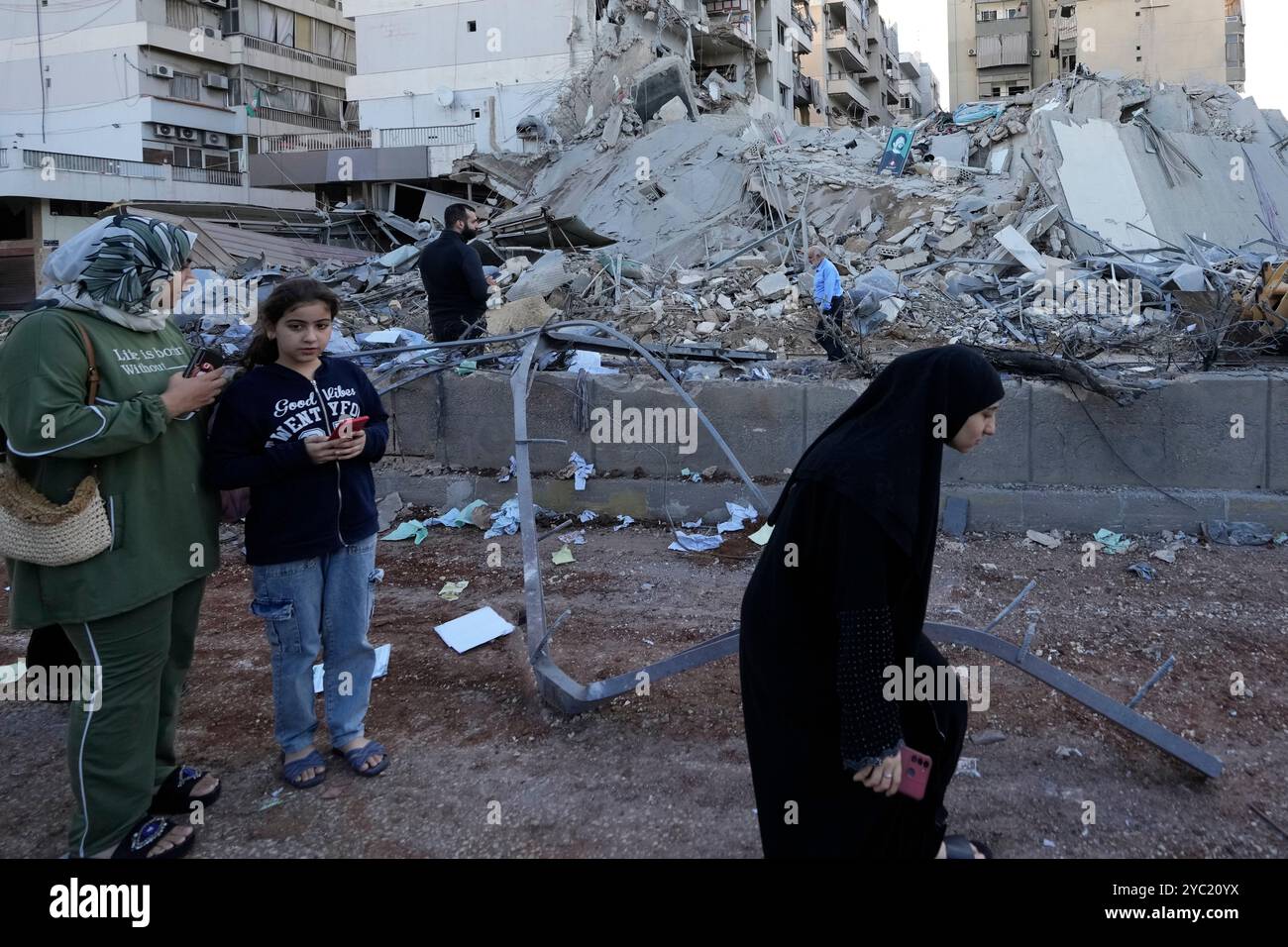 Residents check destroyed buildings at the site of an Israeli airstrike ...