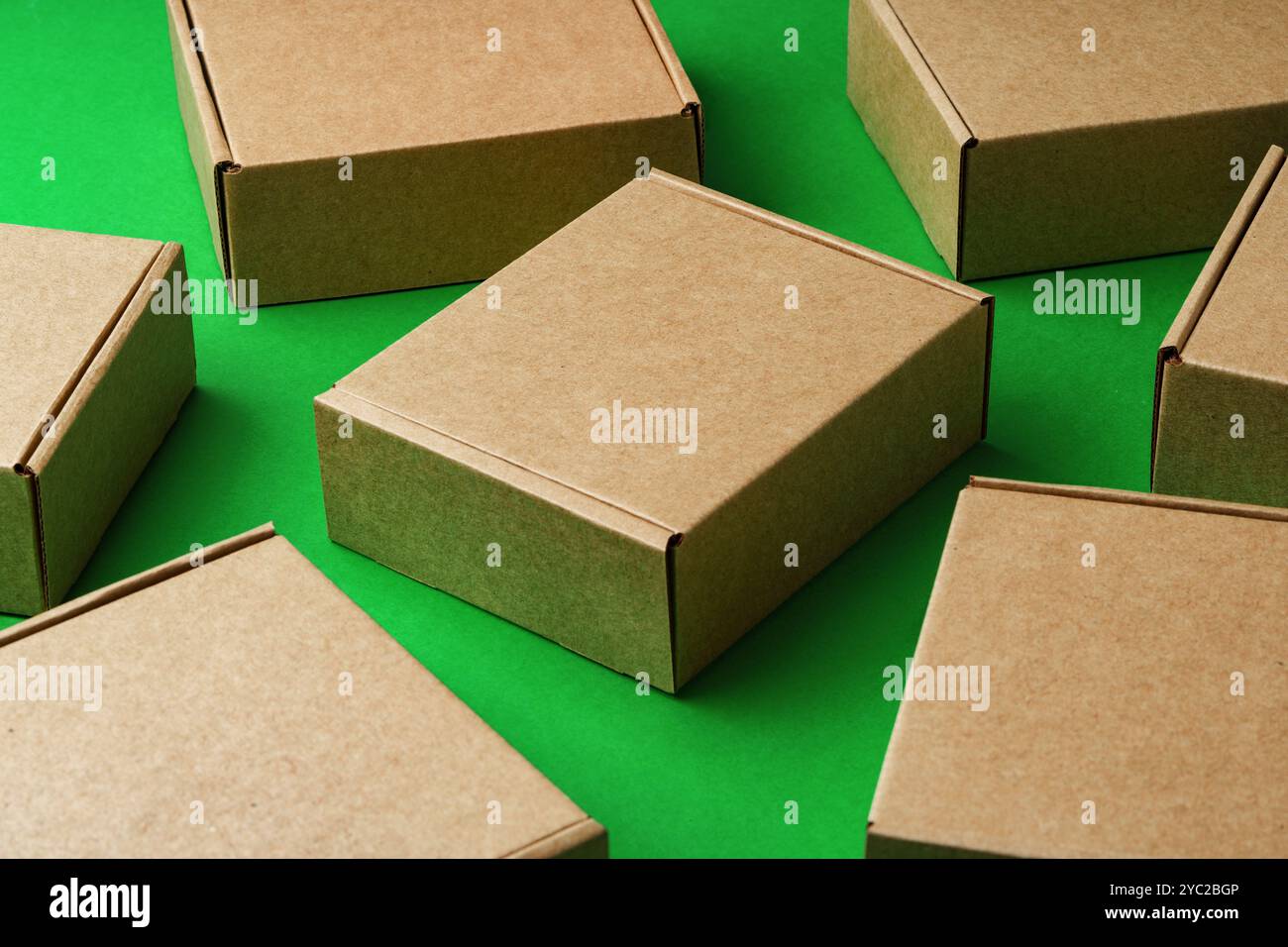 Brown cardboard boxes arranged on a vibrant green surface Stock Photo ...
