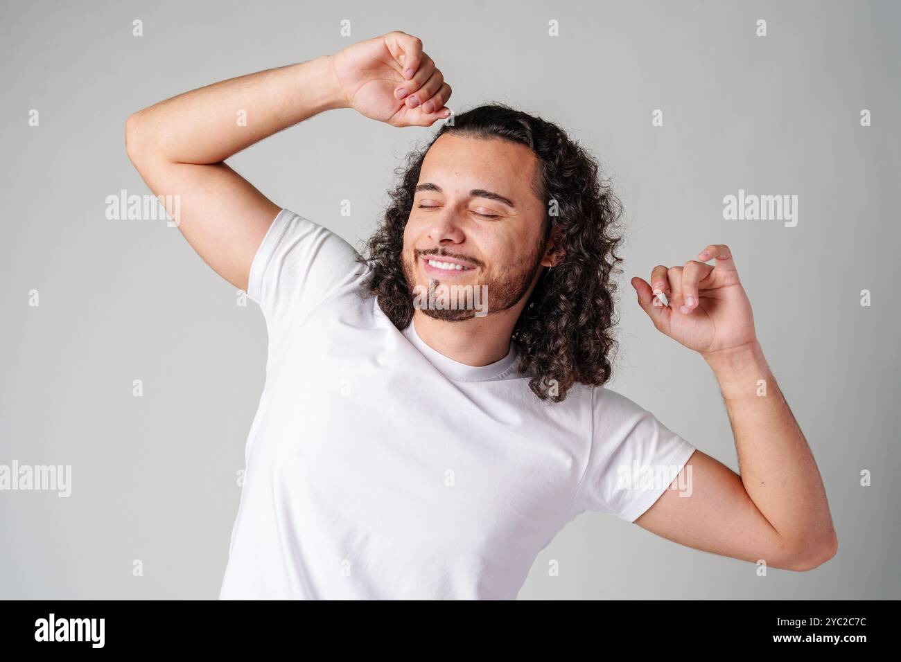 Happy man celebrating success with raised fists in a studio against a ...