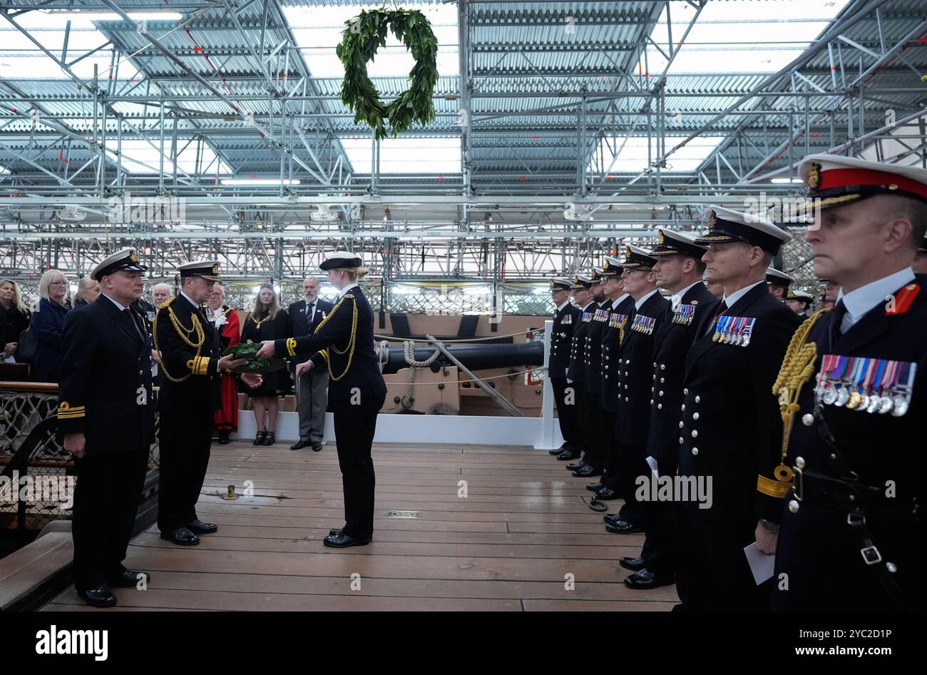Vice Admiral Martin Connell (2nd left) is handed a wreath before laying ...