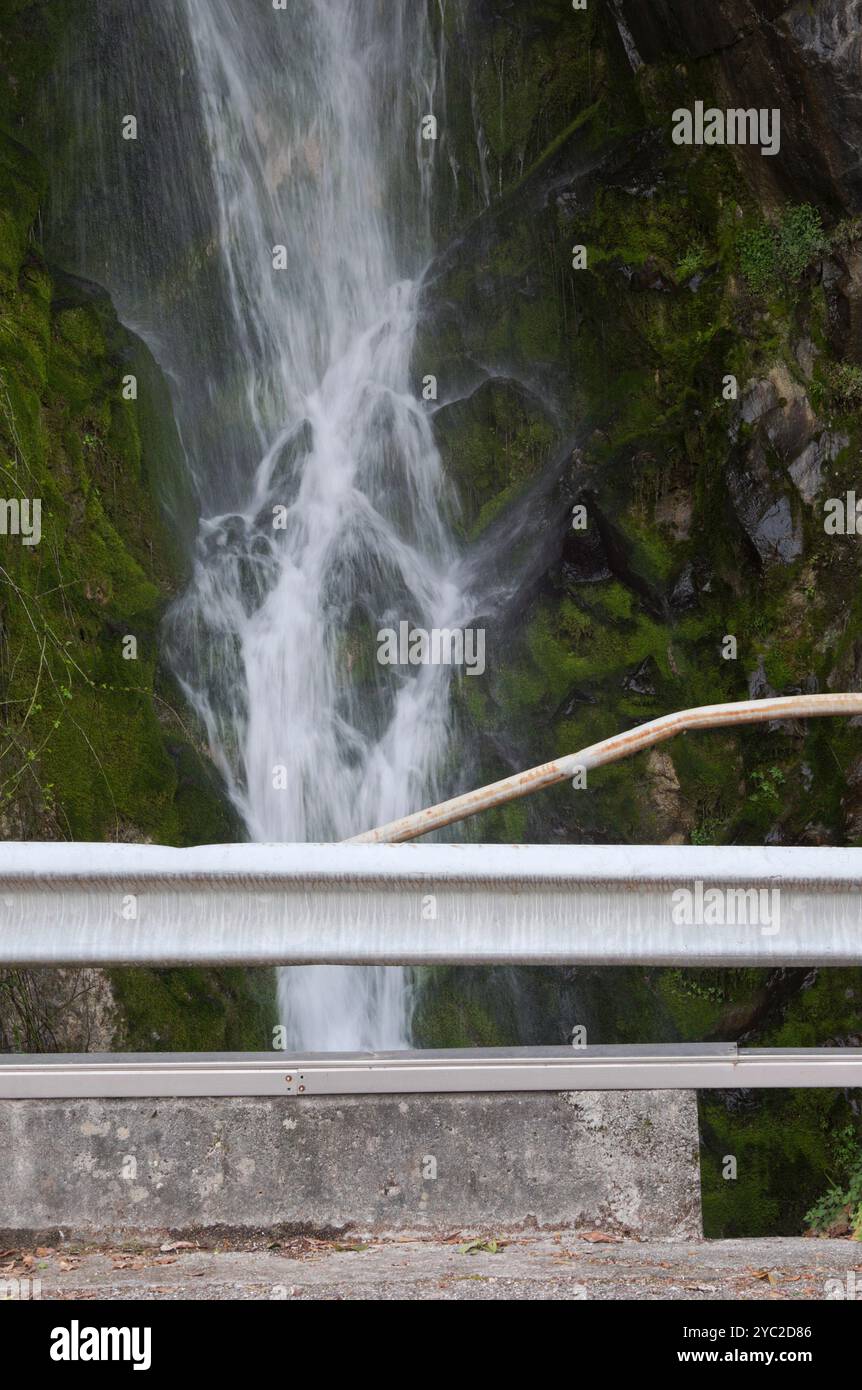 the railing of a bridge overlooking a small waterfall Stock Photo - Alamy