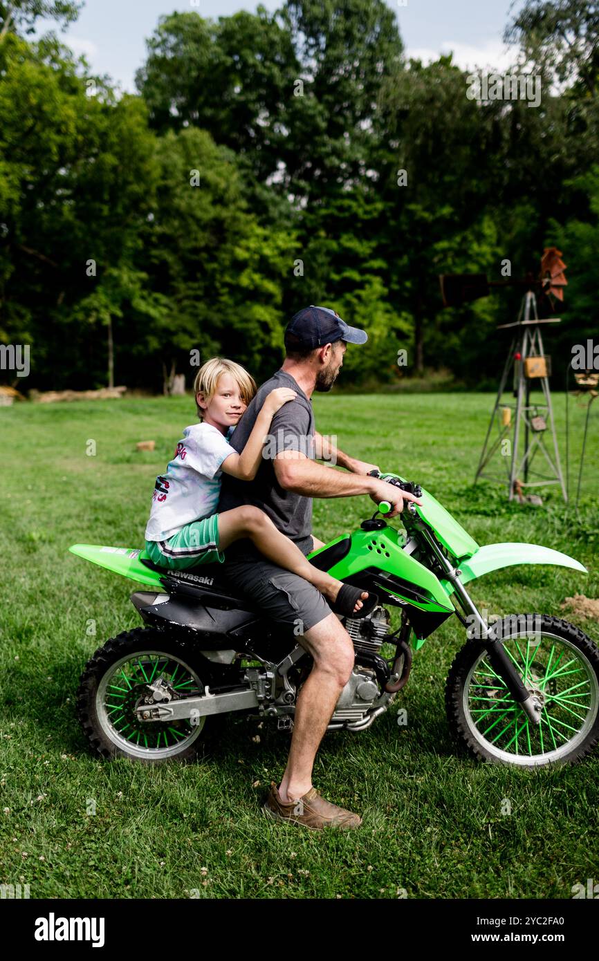 Uncle Taking Nephew on Dirt Bike Ride in Yard in Ohio Stock Photo - Alamy