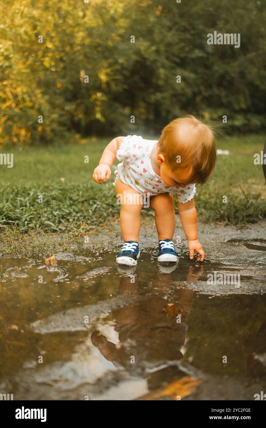 Toddler putting hands and feet in mud puddle Stock Photo - Alamy
