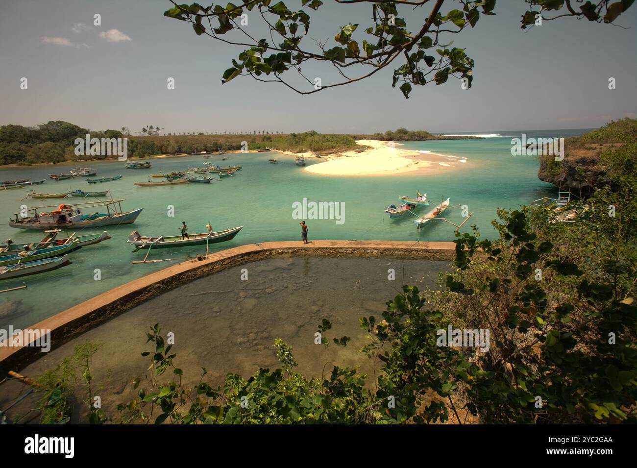 A fisherman standing on a concrete pathway on the fishing beach of Pero ...