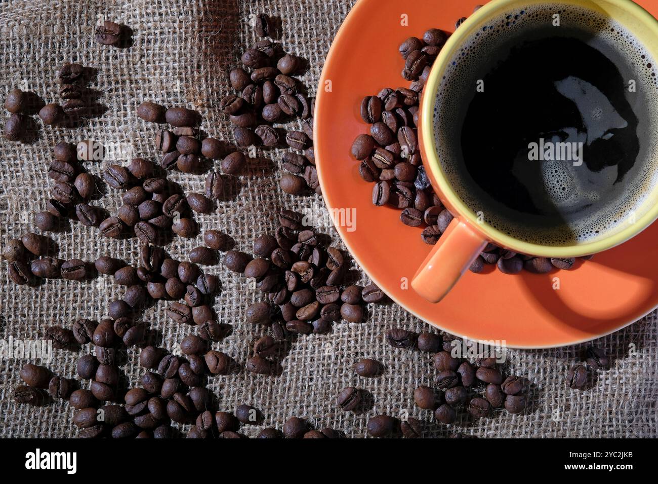 coffee beans on sack cloth with cup and saucer Stock Photo - Alamy