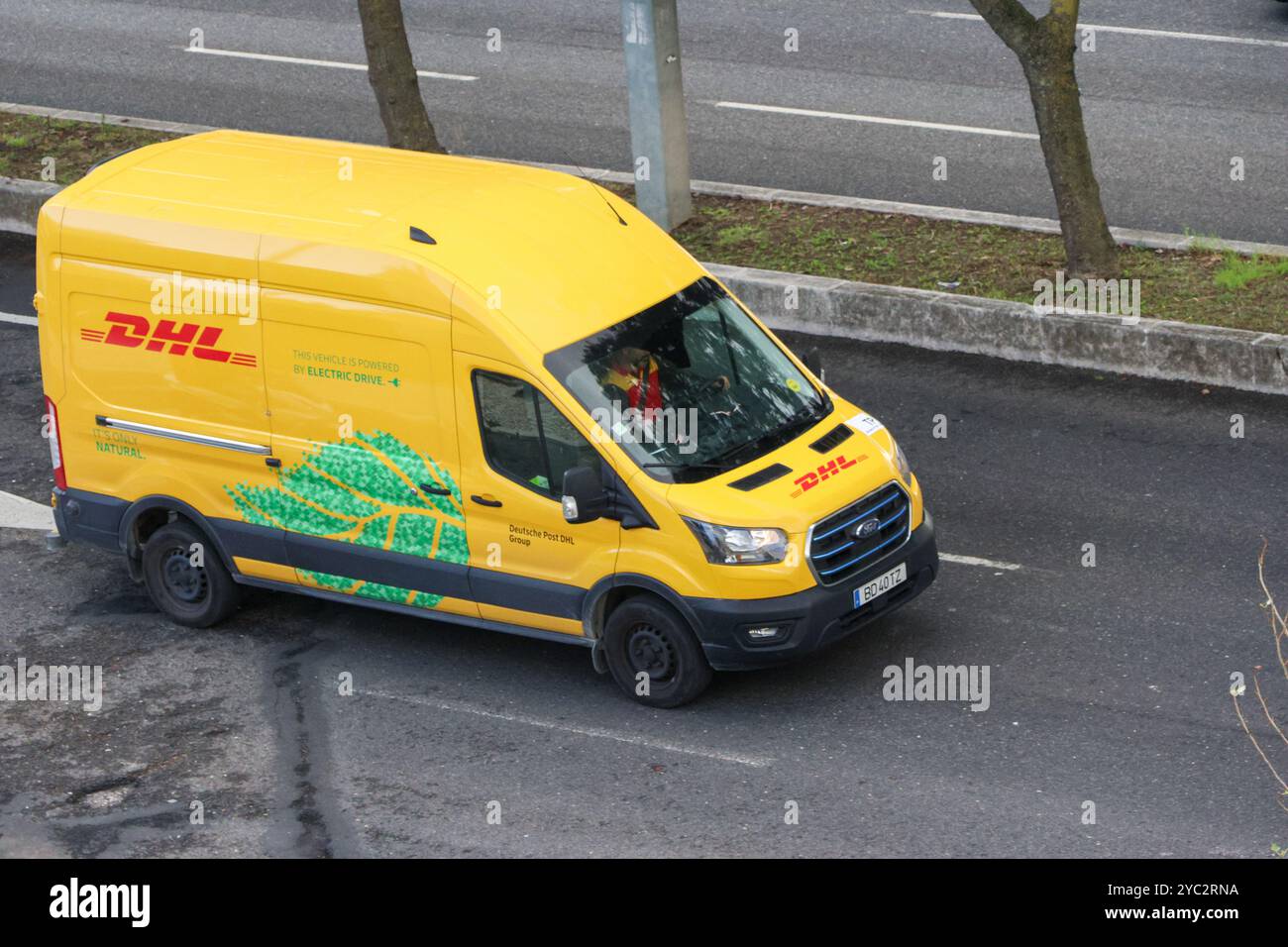 Yellow dhl ford transit courier electric delivery van driving on a road ...