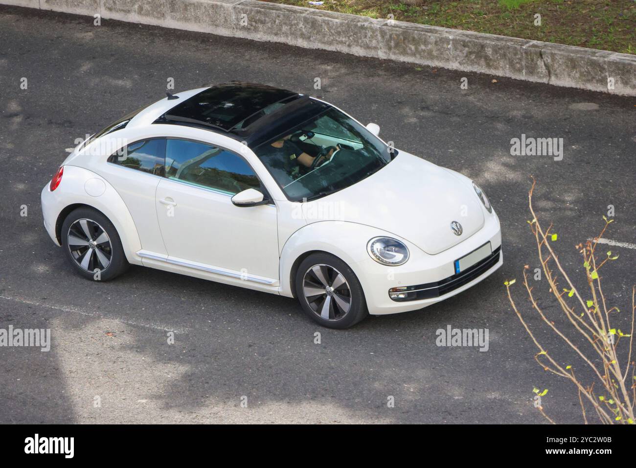 White volkswagen beetle with a sunroof is parked on the side of an ...