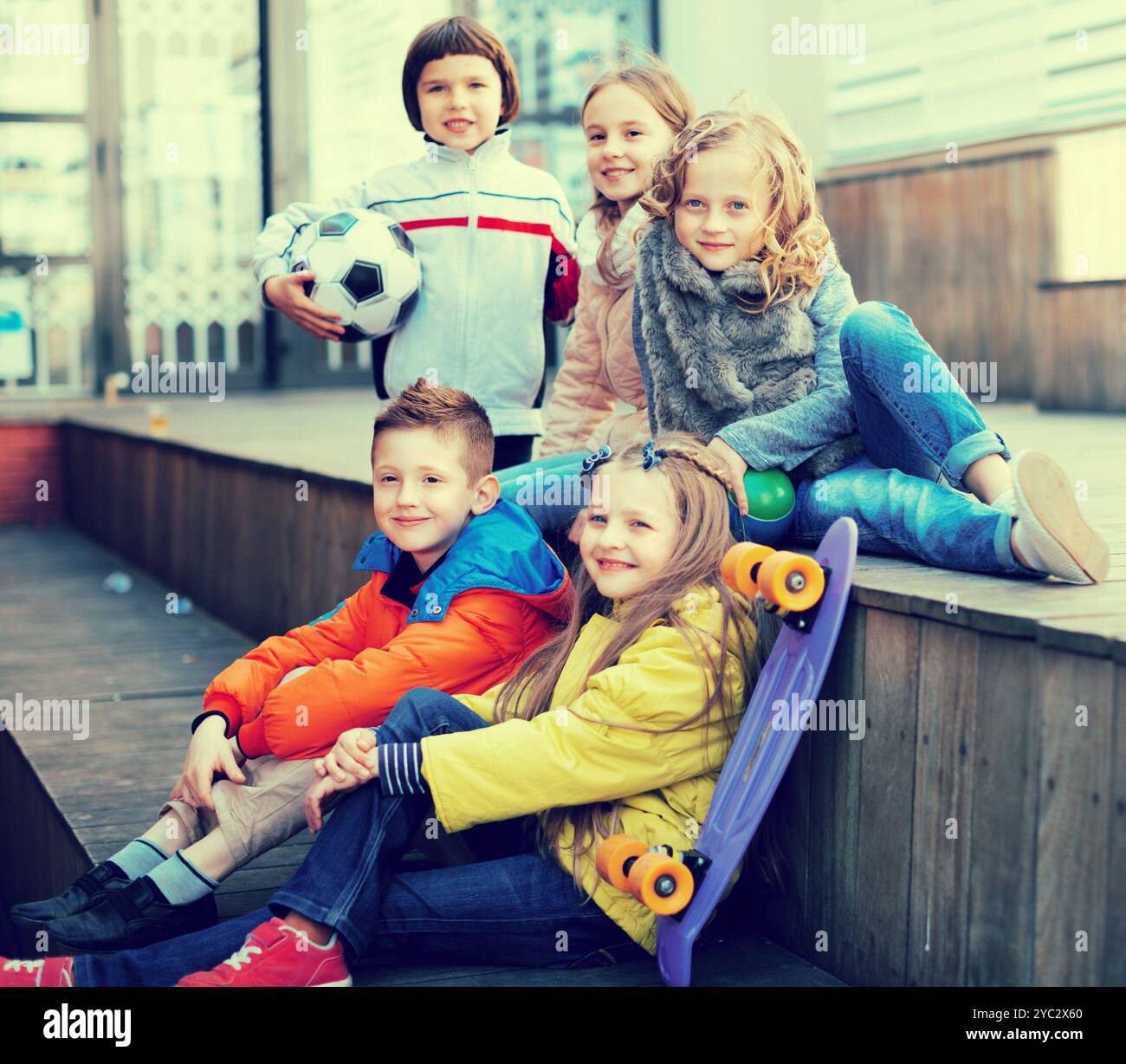 Group of children sitting on wooden scaffolding schoolyard Stock Photo ...
