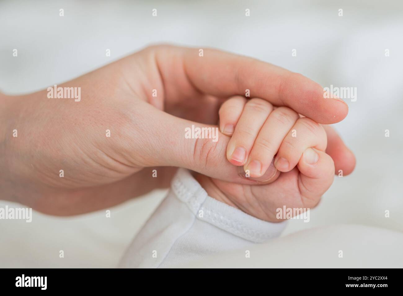 Happy family. Tiny newborn infant baby little hand on mother hand palm ...