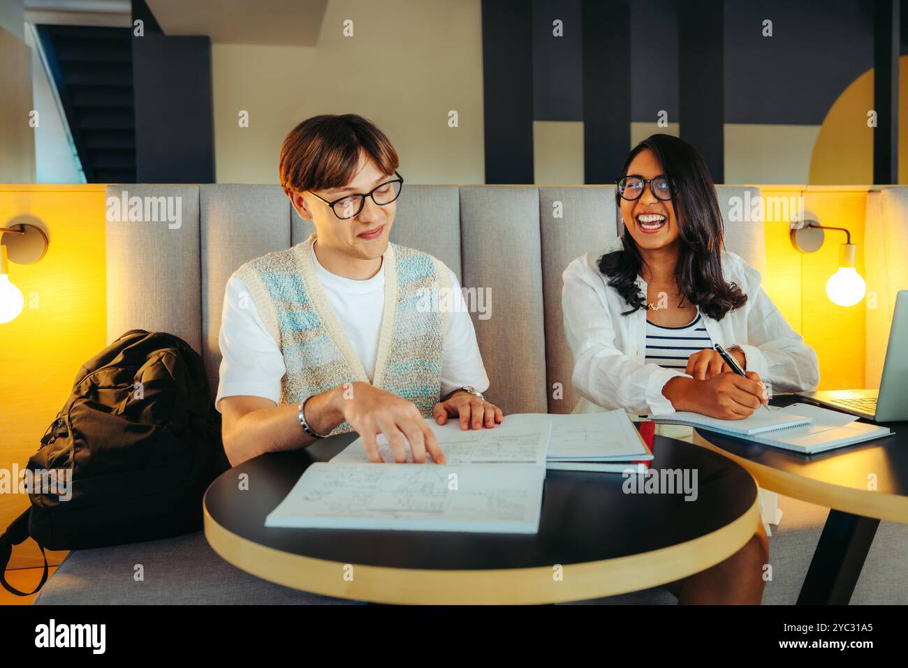 Cheerful students working together on a project in a bright study space ...