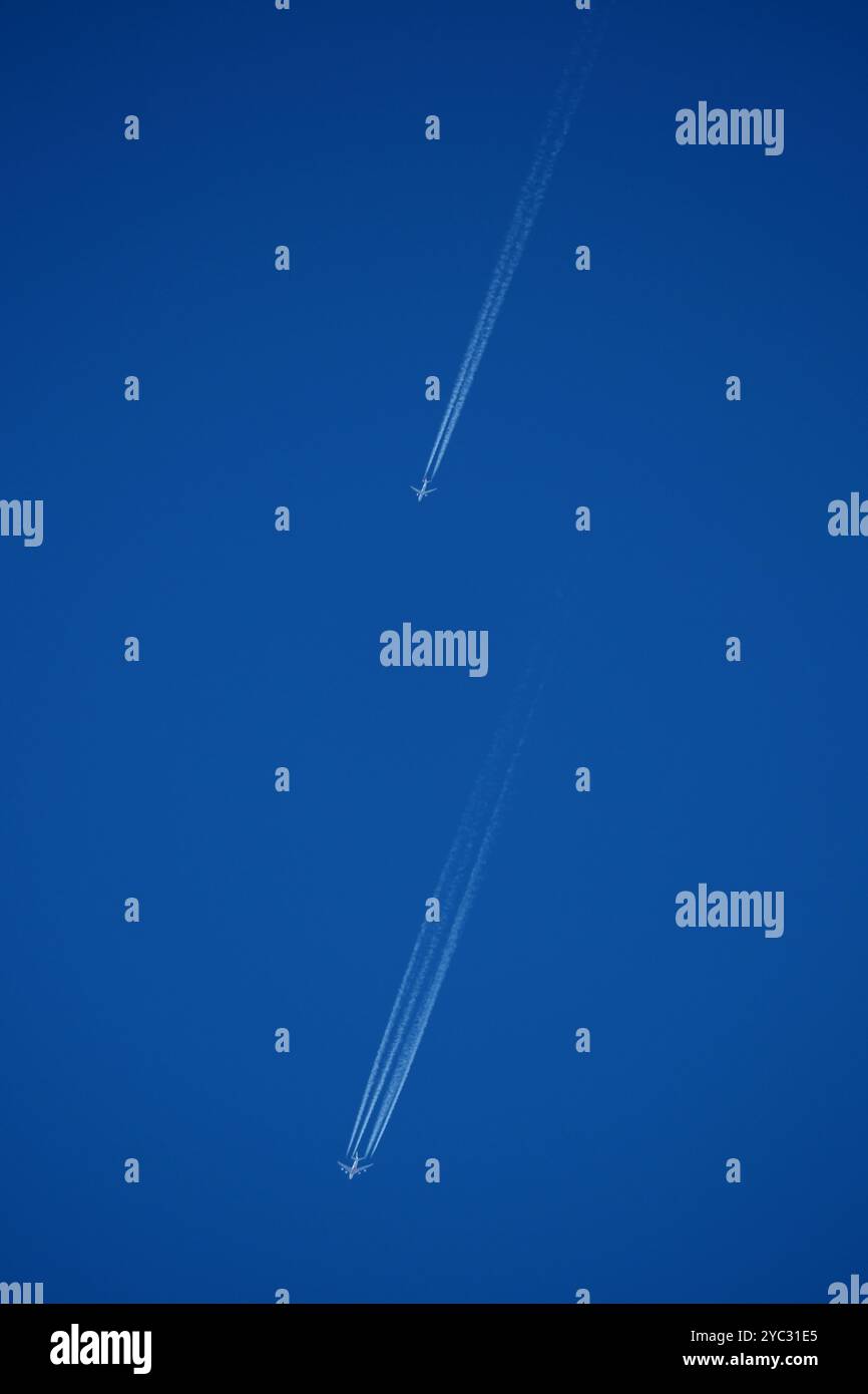 Two airplanes in the blue sky with contrails, closeup of photo ...