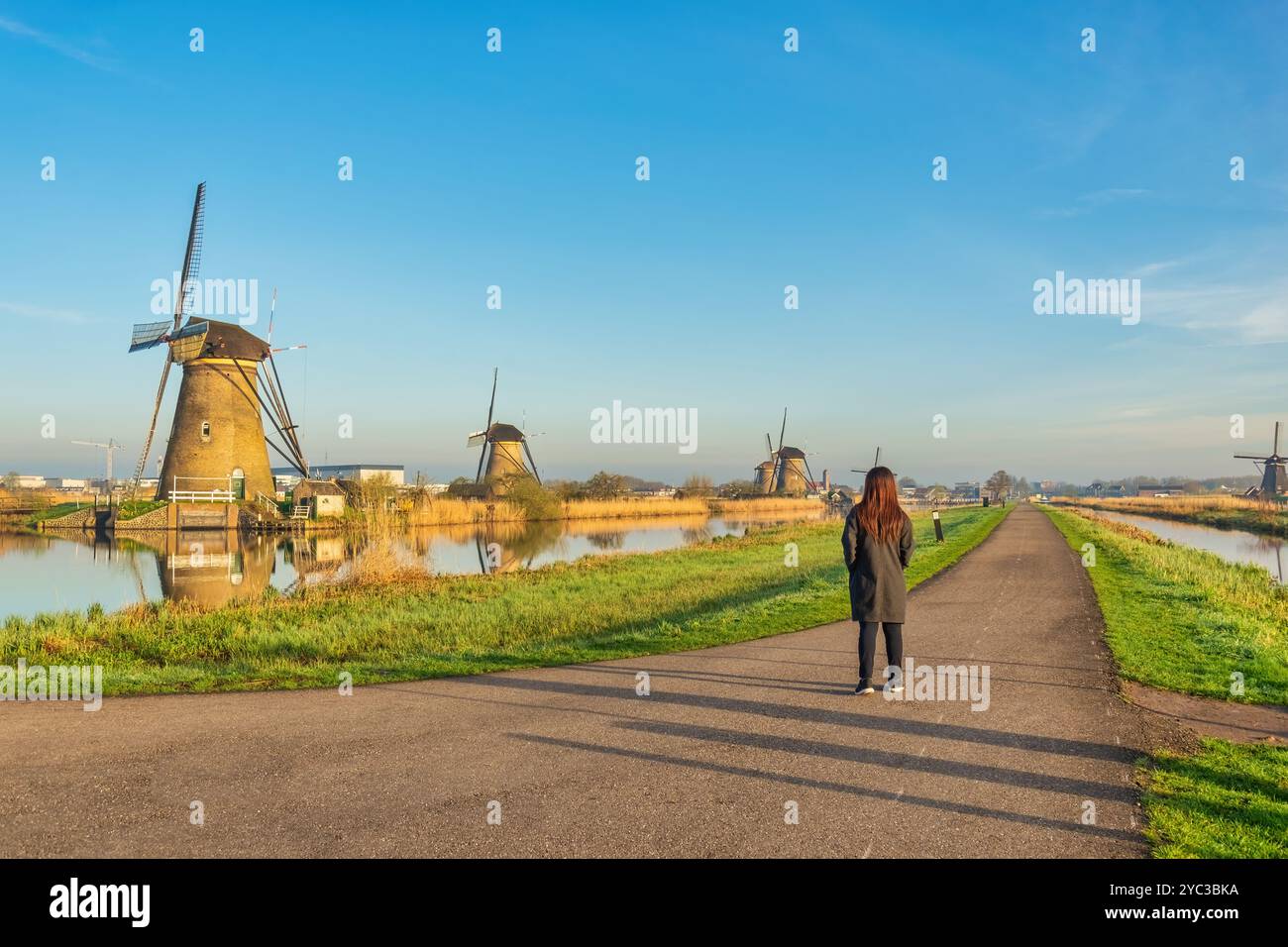 Dutch Windmill landscape at Kinderdijk Village Netherlands with woman ...