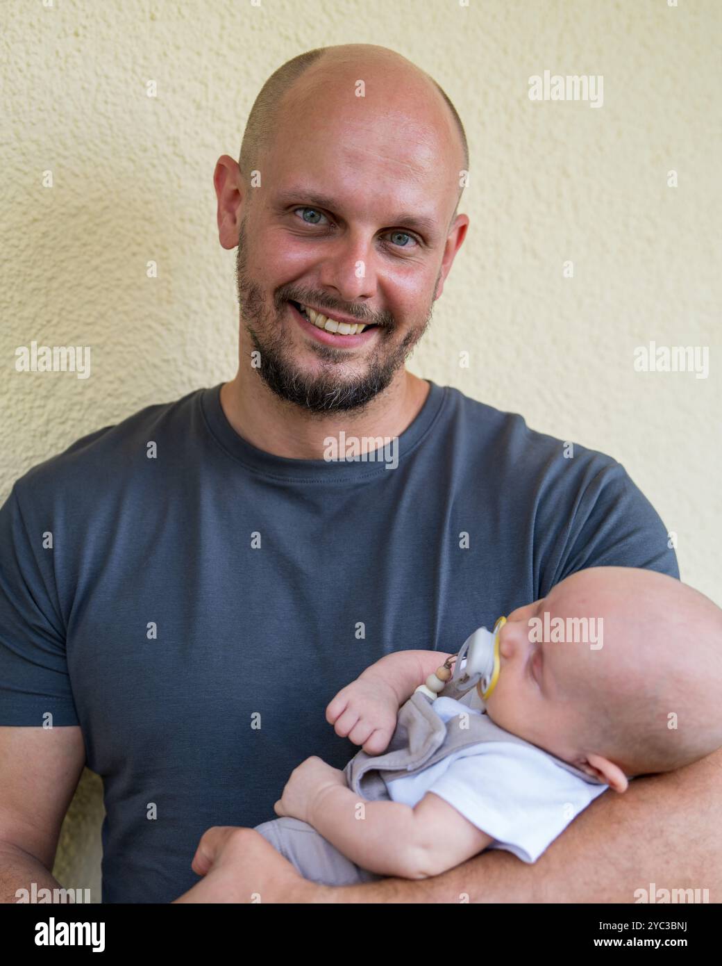 Happy dad holds sleeping newborn son in arms. Father face glows with ...