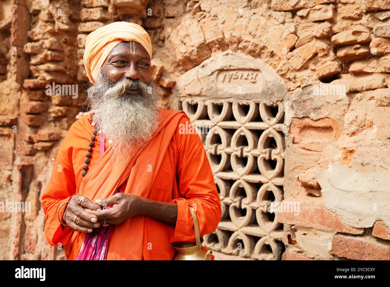 A sadhu poses before a dialopted terracotta mandir of Baidyapur. East ...
