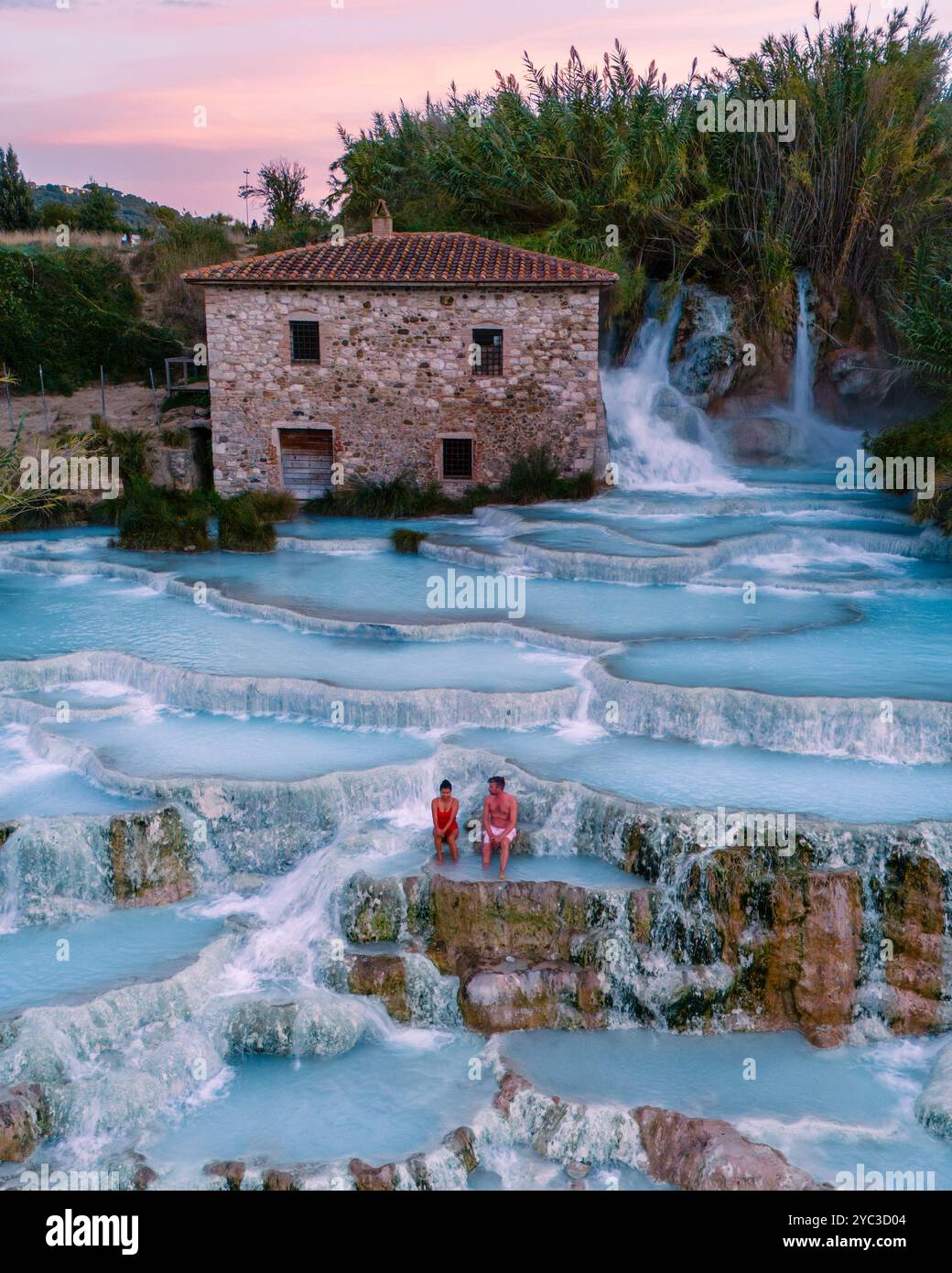 Visitors enjoy the soothing, thermal waters of Saturnia as the sun sets ...